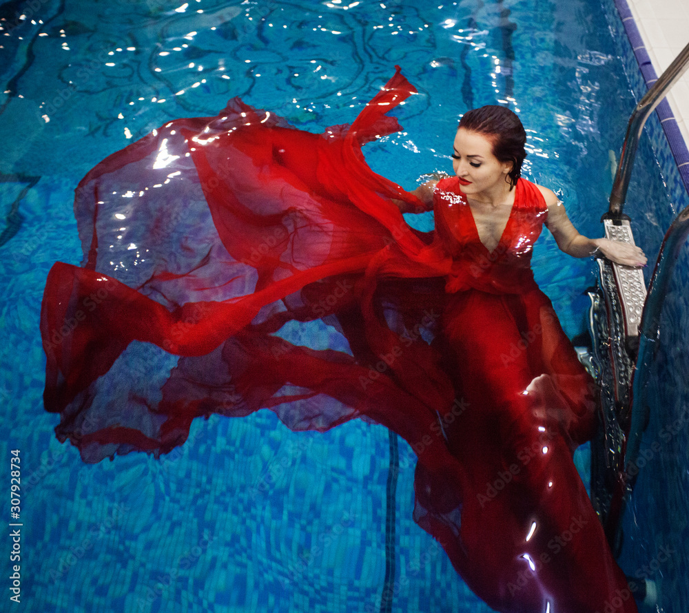 beautiful girl in the pool in a red dress Stock Photo | Adobe Stock