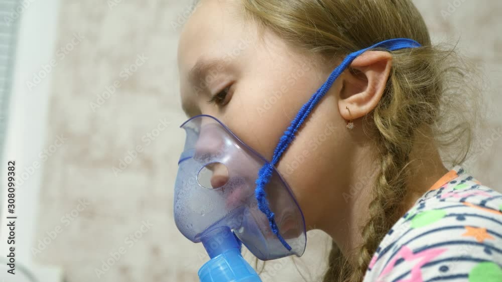 child with a tablet is sick and breathes through an inhaler. close-up ...