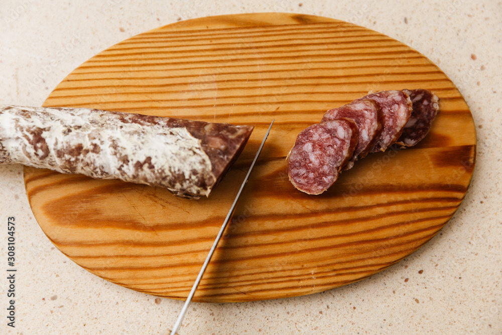 un fuet espetec (longaniza catalana) cortado a cuchillo encima de tabla ...
