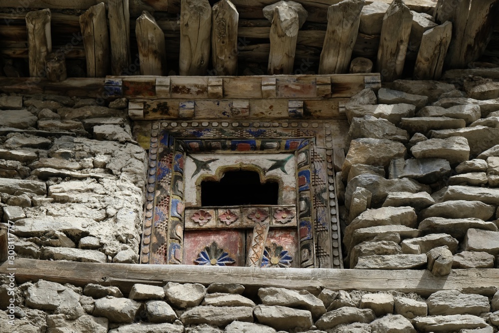 Ornate wooden window in a stone house in the himalayan village of ...