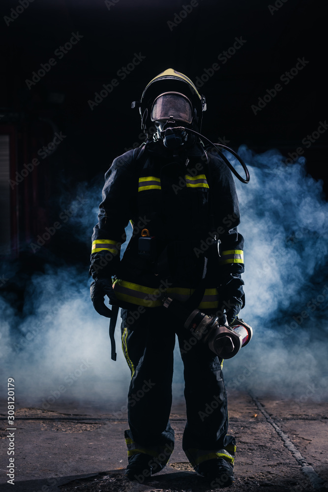 Portrait of a female firefighter wearing a helmet and all safety ...