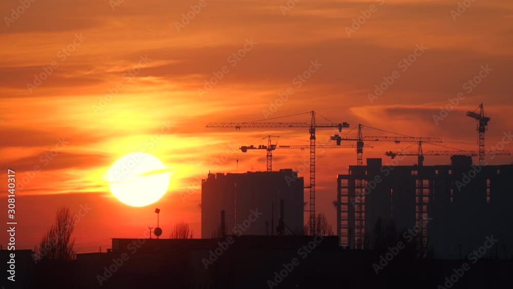 Construction of a high-rise building on a sunset background ...