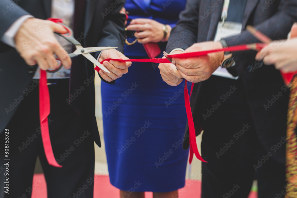 Process of cutting the red ribbon during the grand opening of the new ...