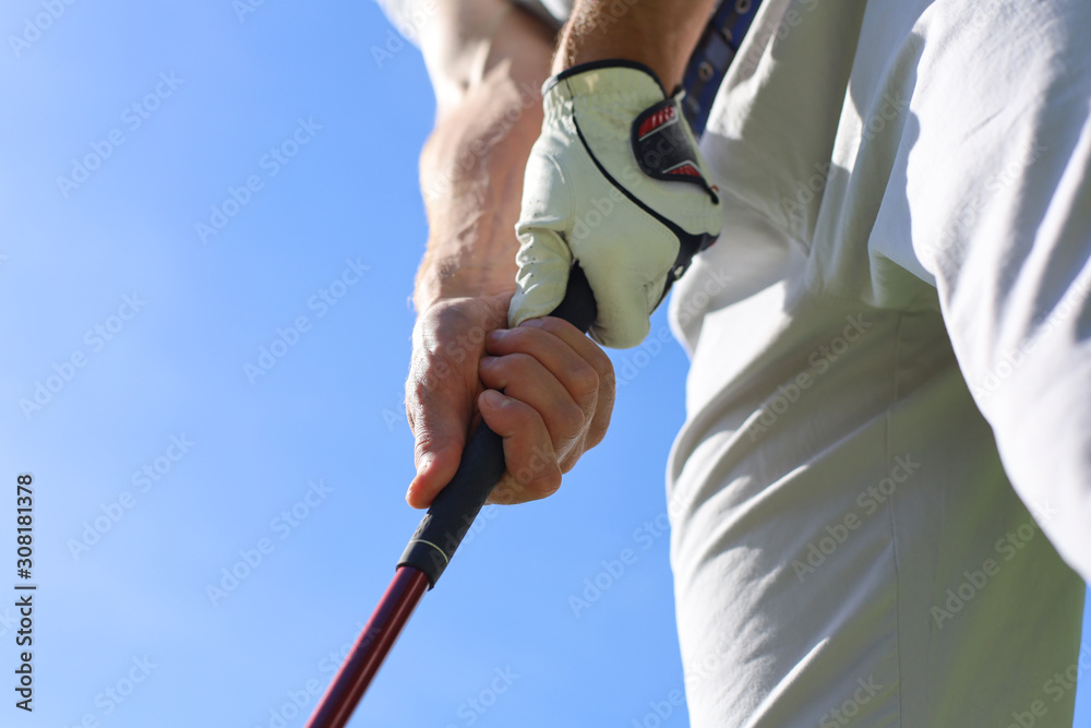Golfer wearing a golf holding a putter. Stock Photo | Adobe Stock