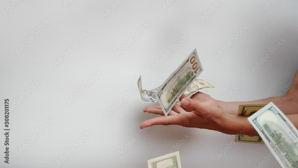Woman's hands try to catch falling US Dollar banknotes falling in slow ...