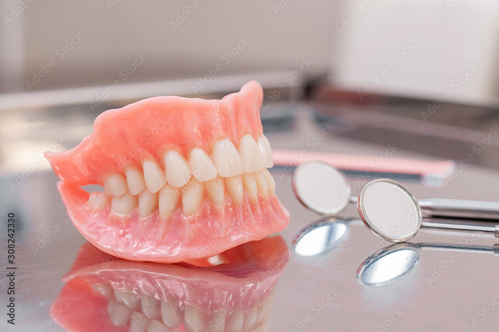 Two dentures. Instruments and dental hygienist checkup concept with ...