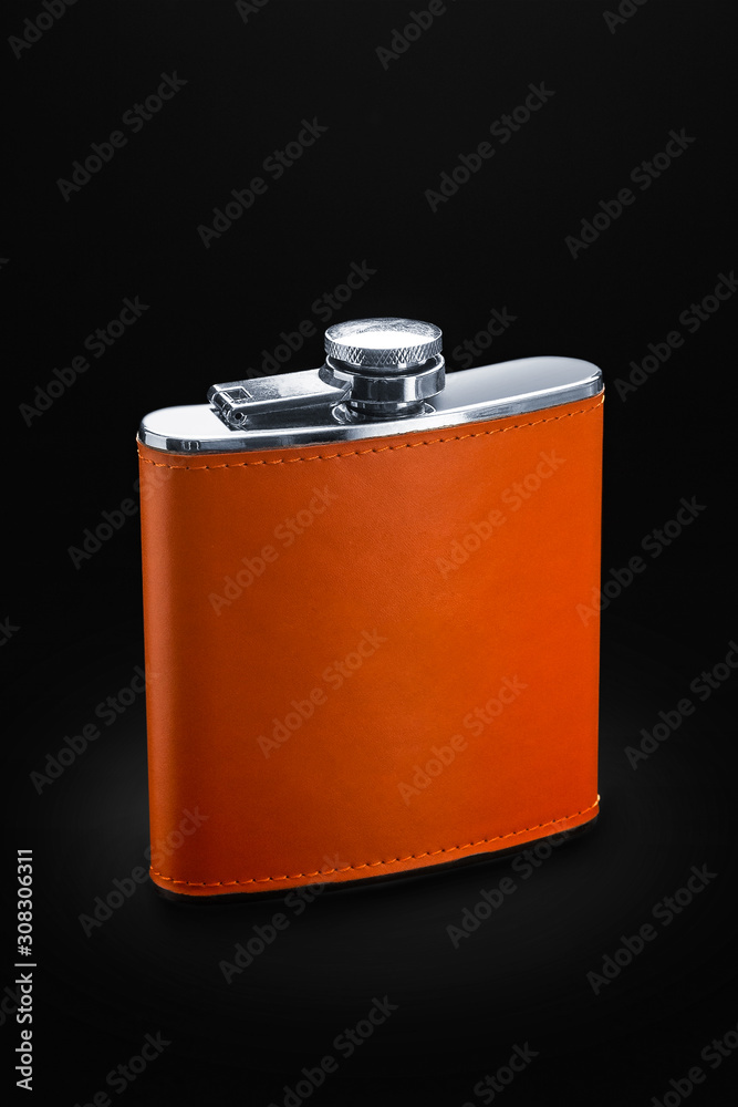 Flask for alcohol is on the table. Steel flaa with orange leather trim ...