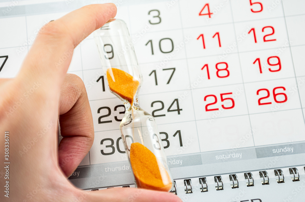 hourglass on the background of the calendar for the month, end of the ...