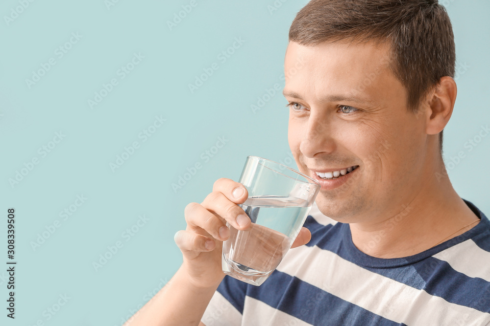 Portrait of handsome man drinking fresh water on color background Stock ...