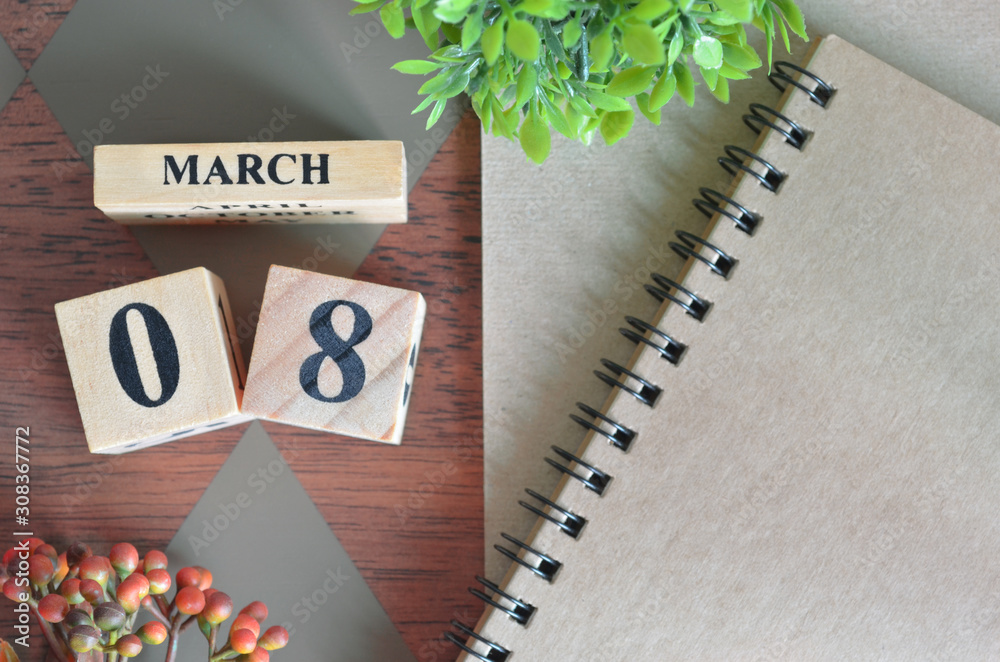 March 8. Date of March month. Number Cube with a flower and notebook on ...