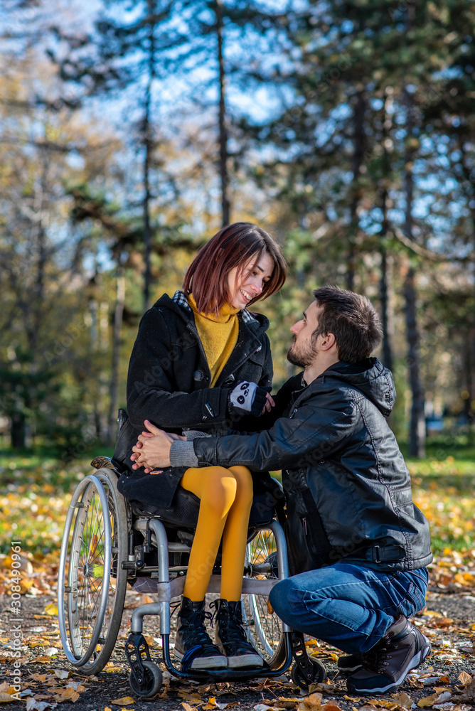 Young disabled woman in a wheelchair with boyfriend. Man with disabled ...