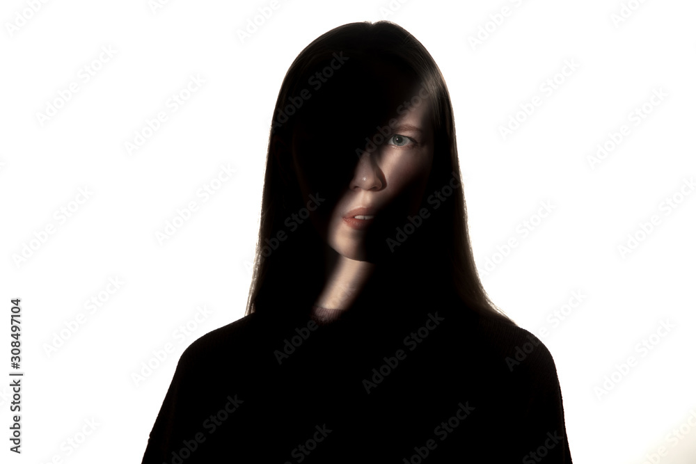 Dramatic portrait of caucasian young girl in the dark isolated on white ...