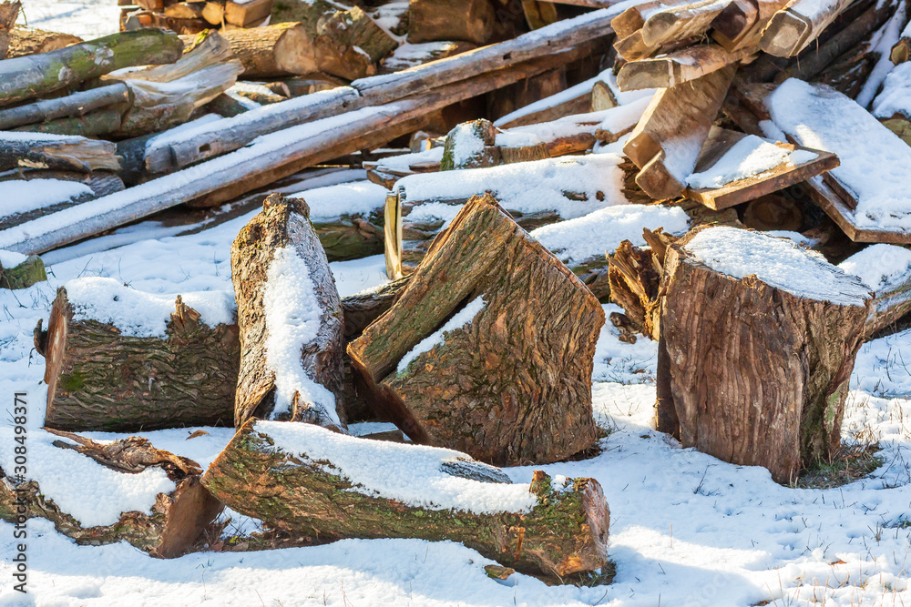 Stacked wood covered with snow. Background. A woodpile of dry fire ...
