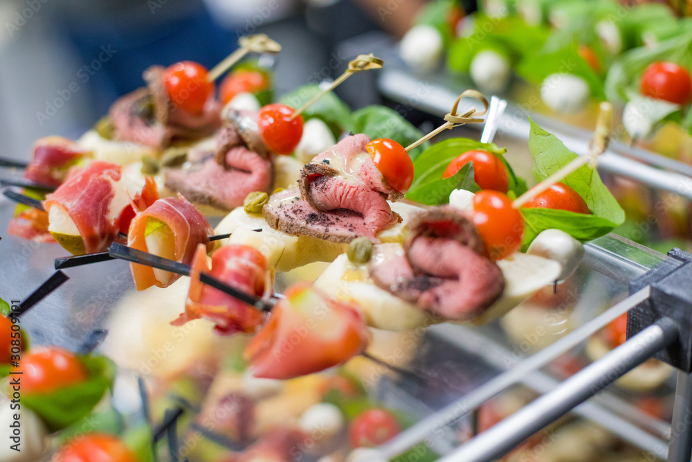 Different canapes with smoked salmon, cucumber, tomatoes, cheese, meat ...