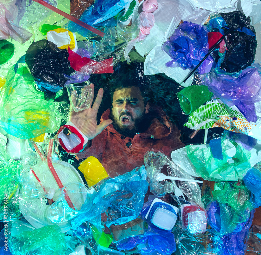 Man drowning in water under plastic recipients pile, garbage. Used ...