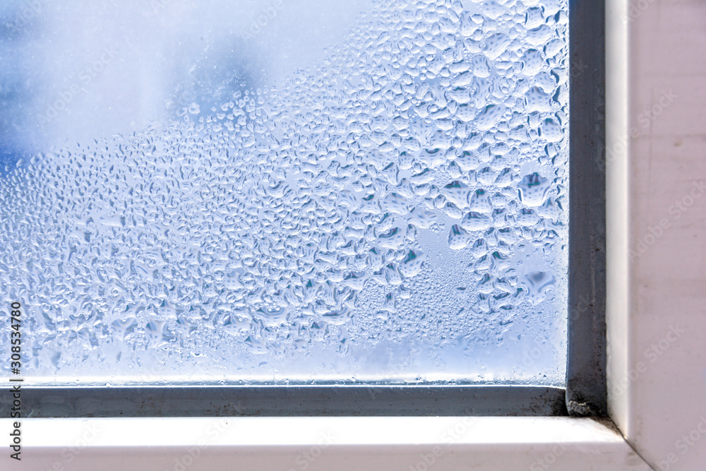 A fragment of a plastic window with condensation of water on the glass ...