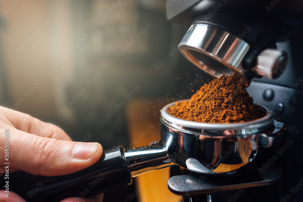 ground coffee pouring into a portafilter with a grinder Stock Photo ...