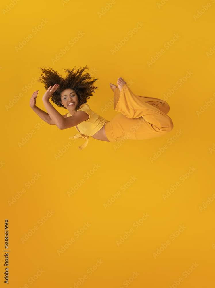 Side view of afro hair woman in zero gravity or a fall. Girl is flying ...