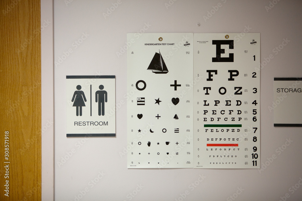 Eye test charts by restroom sign on wall Stock Photo | Adobe Stock