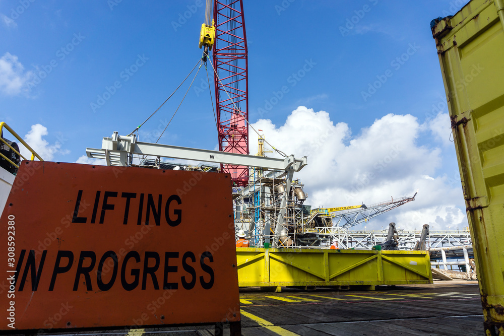 Offshore crane on board a construction work barge performing heavy ...