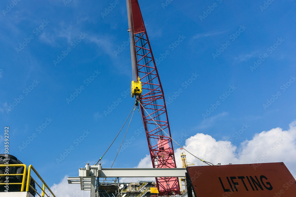 Offshore crane on board a construction work barge performing heavy ...