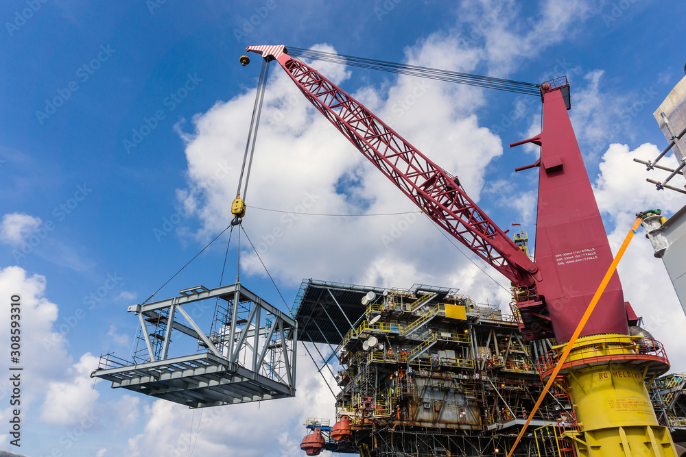 Offshore crane on board a construction work barge performing heavy ...