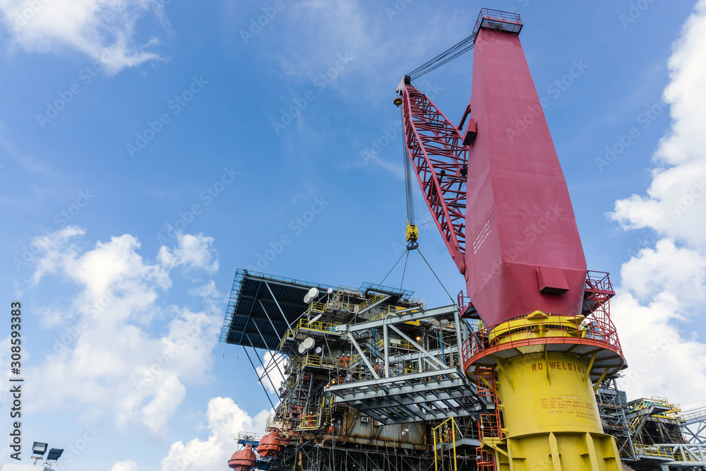 Offshore crane on board a construction work barge performing heavy ...