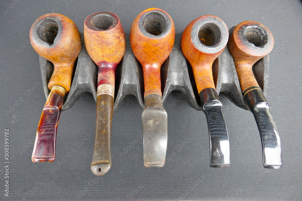 Five old tobacco pipes in a pipe rack Stock Photo | Adobe Stock