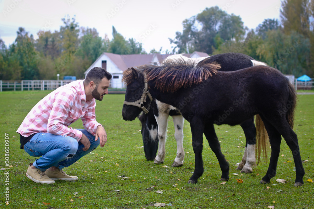 Young handsome guy Cowboy. man is a farmer in his ranch where there are ...
