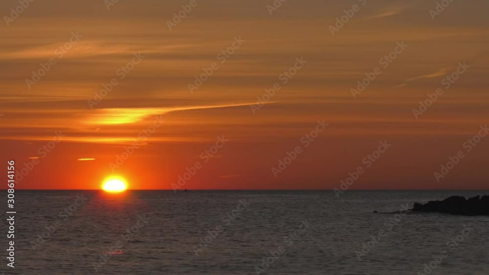 Dramatic sunrise timelapse, sun rising over ocean horizon into orange ...