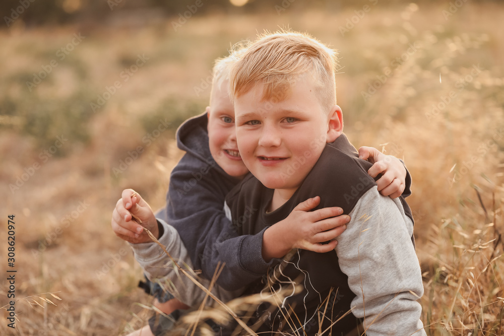 Two young brothers hugging with faces pressed together. Little boy with ...