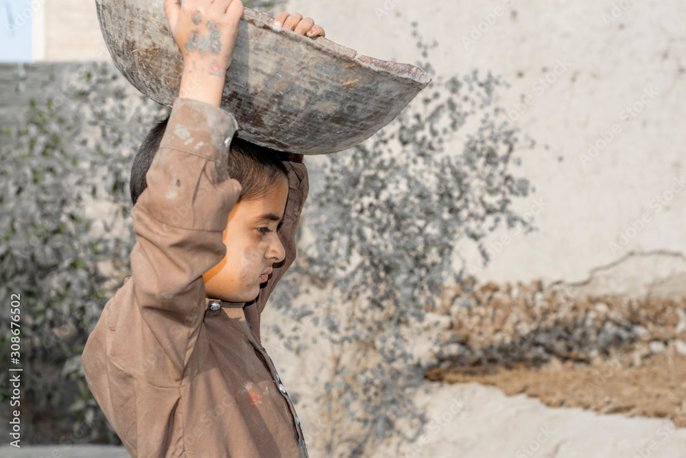 a very young orphan child is forced into child labor and working at a ...
