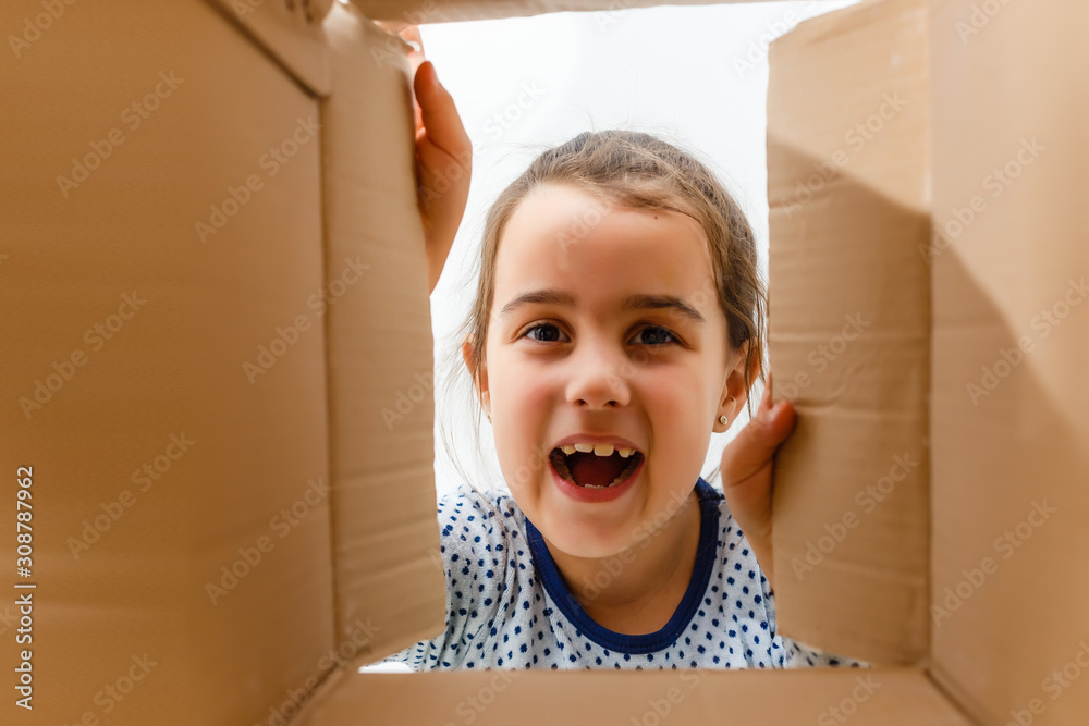 kid girl age 7 year unpacking and opening carton box, and looking ...