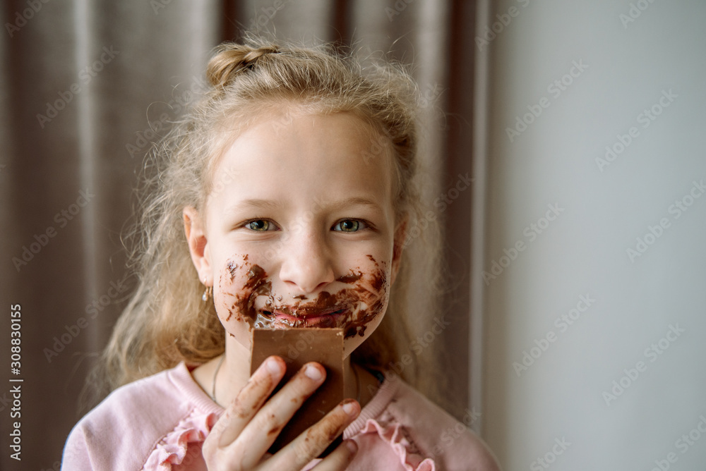 Little girl eating chocolate. a little girl smeared chocolate. a sweet ...