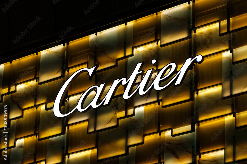 Logo, signage, emblem of the brand Cartier on shop facade in Hongkong ...
