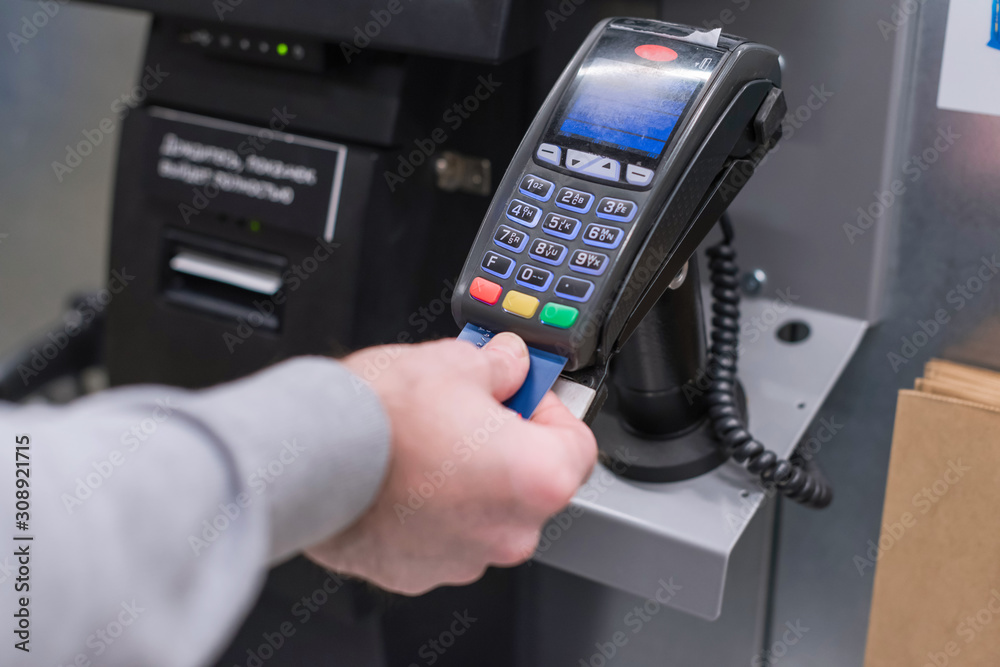Foto de Man paying at the self-service counter entering credit card pin ...
