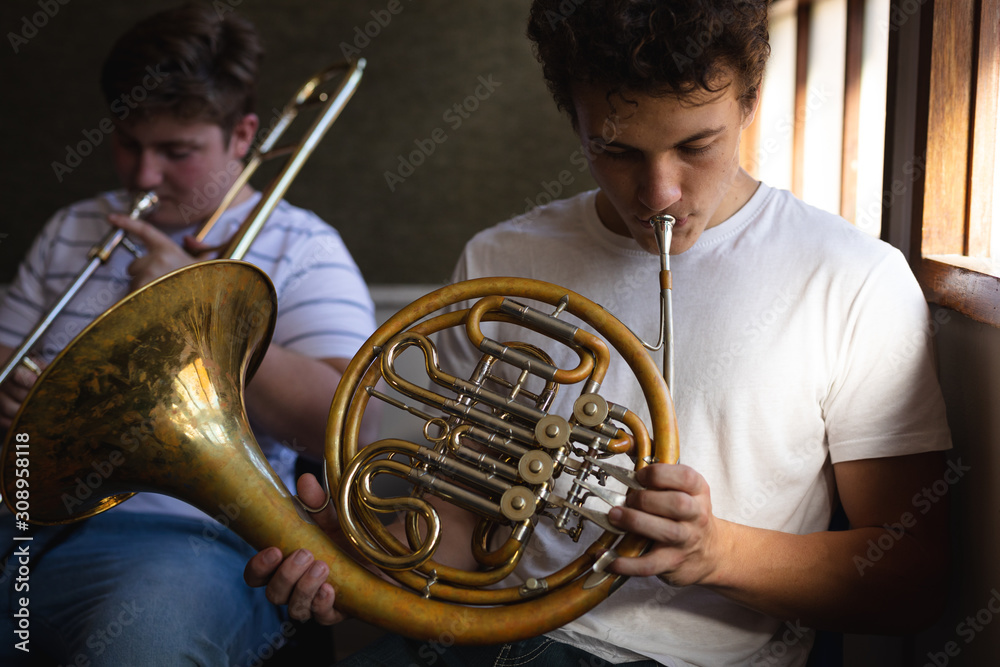 Teenage boys playing musical instruments in music school Stock Photo ...