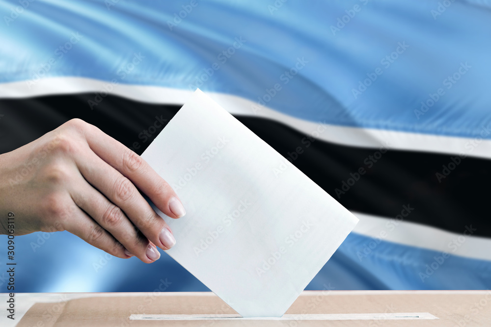Botswana election concept. Side view woman putting a ballot in a box on ...