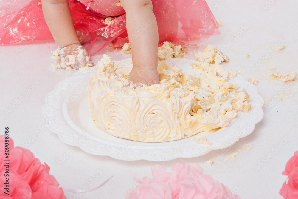 little girl eating cake with her hands on white background. The child ...