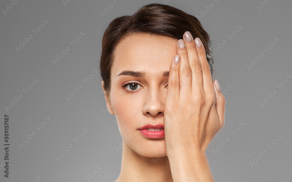 vision, beauty and people concept - beautiful young woman closing one ...