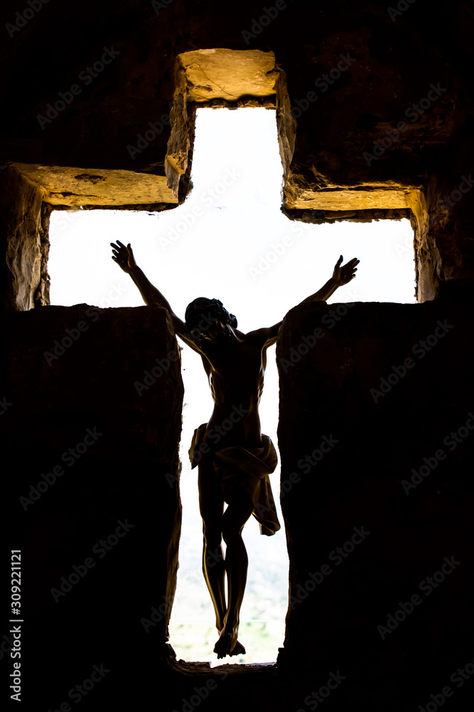 Jesus figure in a cross shaped window frame in old church in Lebanon ...