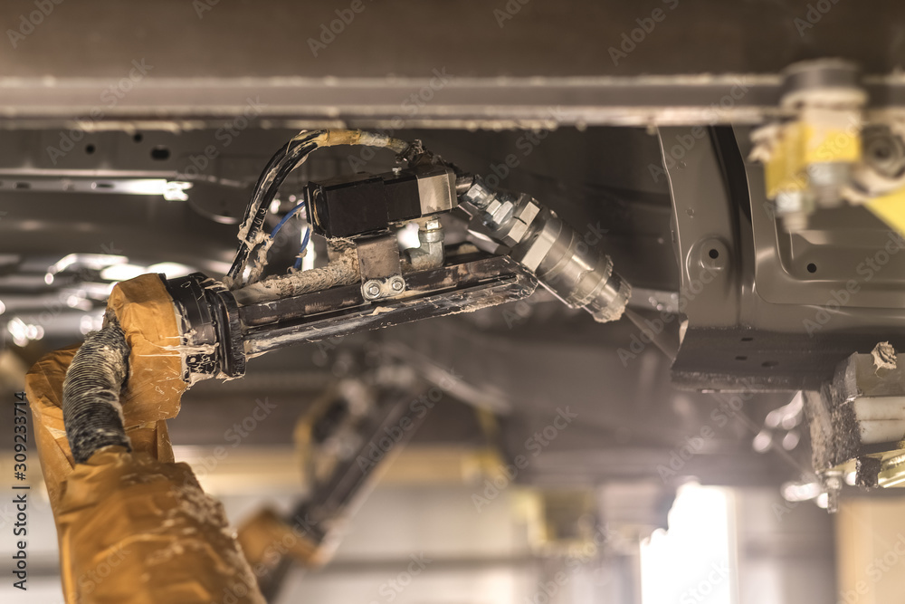 Production line of automobile plant, painting shop. Applying sealant to ...