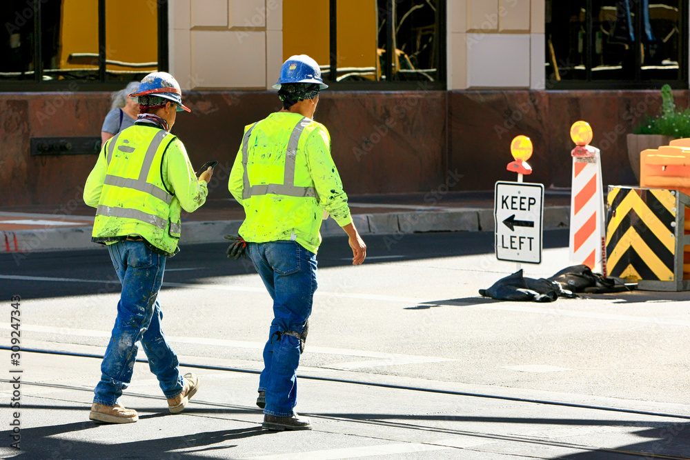 Foto de Two construction workers wearing their hard-hats and high viz ...