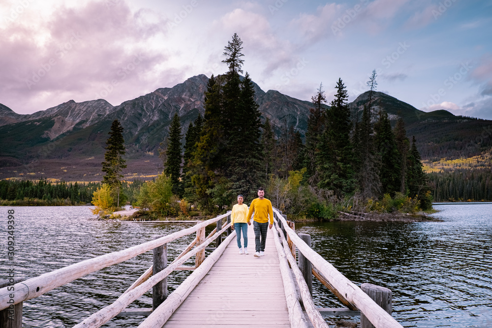 couple by the lake watching sunset, Pyramid lake Jasper during autumn ...