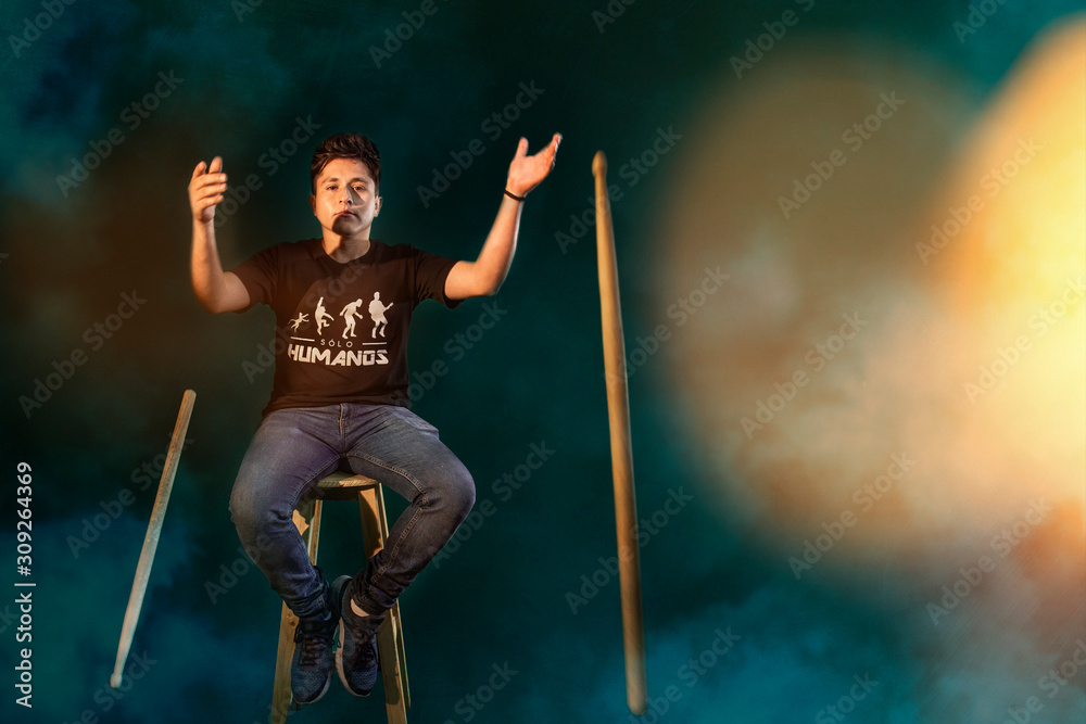 Rock band drummer raising his arms, throwing drumsticks in the air on ...