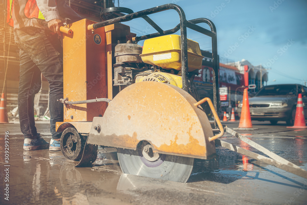 cutting concrete floor with worker cutting concrete road with diamond ...
