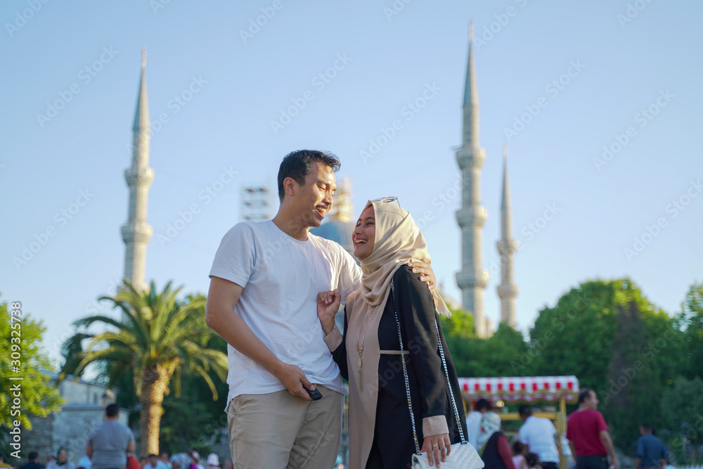 a young couple traveller happy pose at the biggest mosque in Istanbul ...