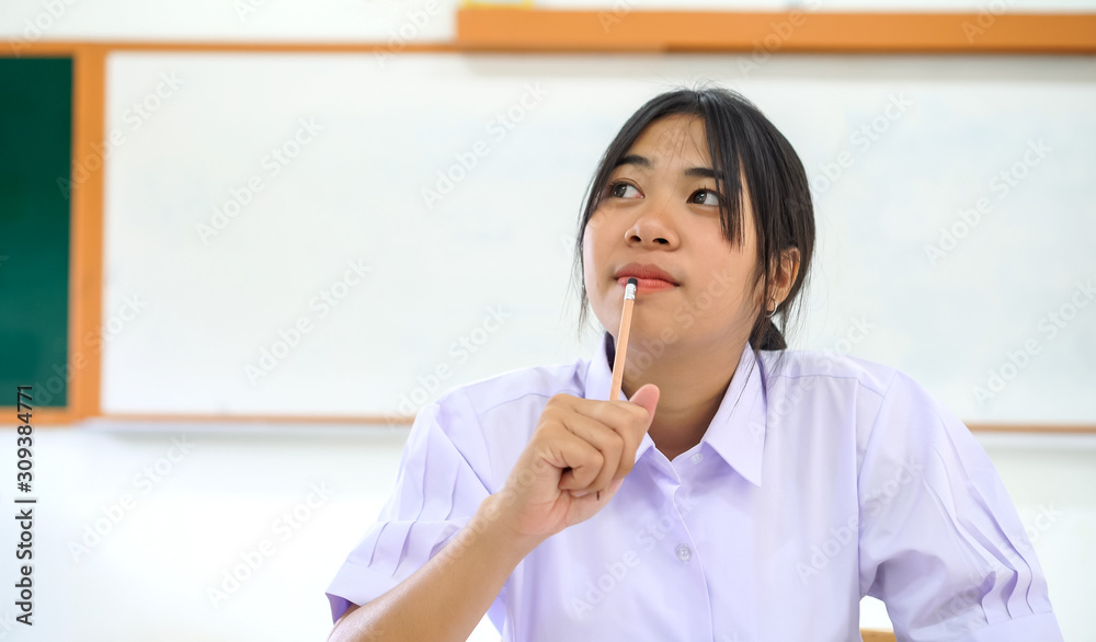 asian student girl thinking for taking homework or reading book alone ...