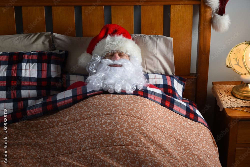 Santa Claus sleeping in his bed at the North Pole after his Christmas ...