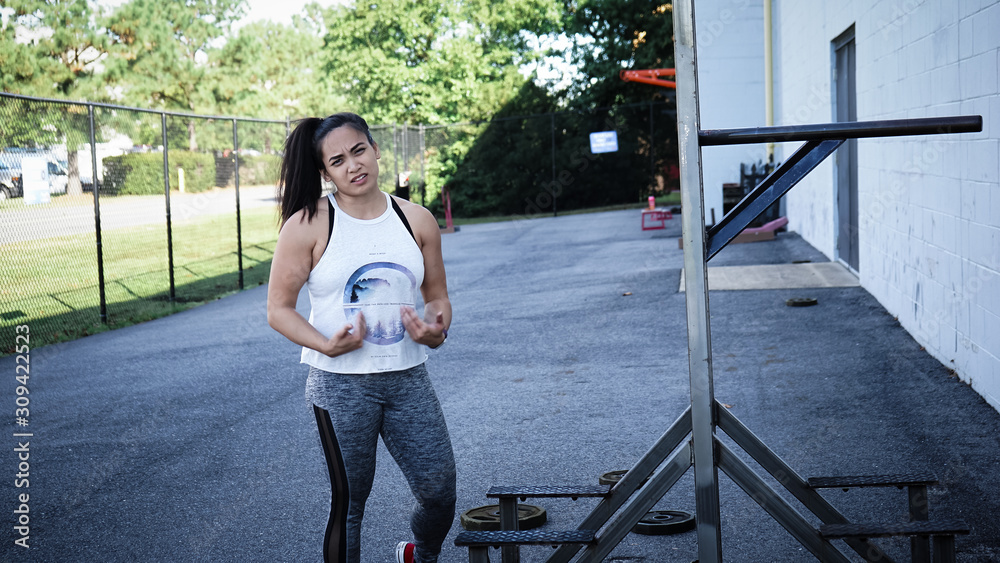 A young adult filipino woman exerting energy during her weight lifting ...